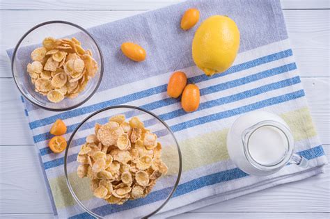 콘플레이크와 그릇 우유와 준비 된 맛 있는 아침 식사에 대 한 빈 그릇의 용기 우유와 과일 나무 테이블 평면도 콘플레이크 건강