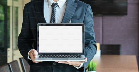 회의실 앞에 격리된 노트북 컴퓨터를 보여주는 양복을 입은 자른 총에 맞은 남자 사진 Unsplash의 태국 이미지