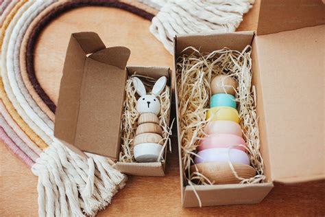 나무 테이블에 공예 상자에 아이를 위한 세련된 나무 장난감 무지개 색과 토끼의 반지가 있는 현대적인 다채로운 나무 피라미드 유아를위한 친환경 플라스틱 무료 장난감 사진