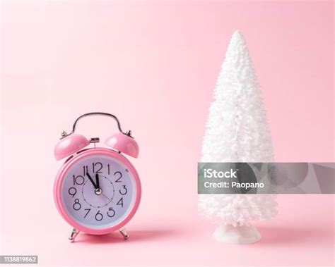 분홍색 배경에 알람 시계와 눈 덮인 크리스마스 트리 크리스마스 또는 새 해 최소 개념입니다 0명에 대한 스톡 사진 및 기타 이미지 Istock