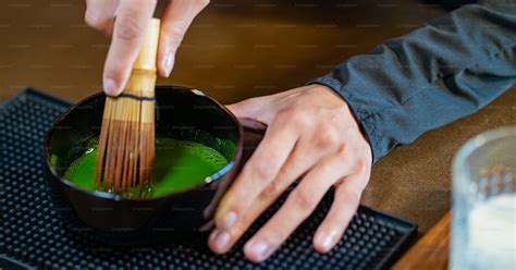 아시아 여성 바리스타가 잔에 신선한 우유로 말차 녹차를 만들고 있다 여성 커피 숍 웨이트리스는 카페의 카운터에서 고객에게 아이스 말차 라떼를 제공합니다 중소 기업 커피