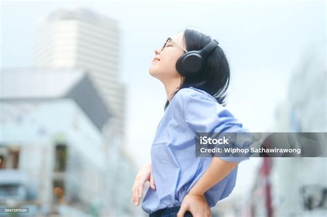 젊은 성인 아시아 여성은 무선 헤드폰을 착용하고 긍정적 인 자기 사랑을 가진 도시 사람들의 라이프 스타일을 착용합니다 여자에