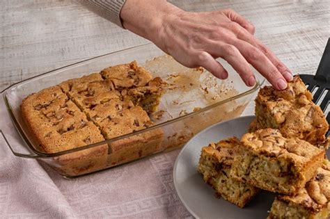 유리 그릇에 담긴 과일과 베리 파이 조각을 주걱으로 꺼내 접시에 놓습니다 접시에 사과 파이 조각을 놓는 여성의 손 클로즈업 파이 요리의 개념 가정 생활에 대한 스톡 사진 및
