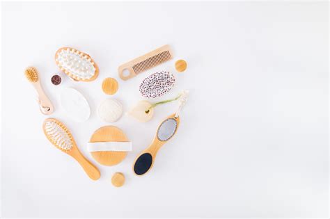 흰색 배경에 심장 모양의 자기 신체 관리를위한 제로 폐기물 키트 친환경 플라스틱 무료 대나무 브러쉬 비누 스크럽 피부 버터 빗 천연 욕실 필수품 지속 가능한 라이프 스타일을