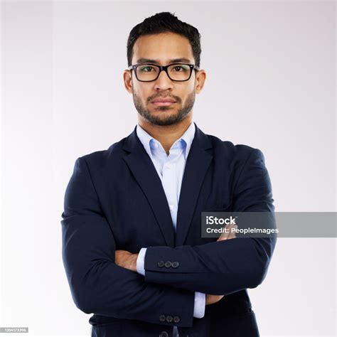 팔을 들고 서있는 자신감 있는 젊은 사업가의 스튜디오 초상화가 흰색 배경을 가로질러 넘어갔습니다 인물 사진에 대한 스톡 사진 및