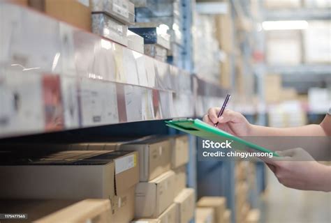 클립 보드 파일과 펜을 사용하여 창고의 선반에 골판지 상자에 제품 관리의 재고를하고아시아 관리자 남자 공장에서 재고를 확인 하는 남성 전문 도우미 실제 인벤토리 수입니다