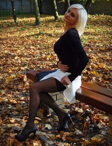 Блондинка в парке в чулках светит резинку Blondy in stockings in park at street nature Black