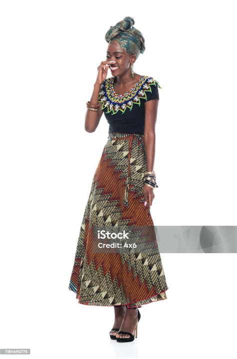 2029세의 아프리카 민족아프리카계 민족의 전체 길이 젊은 여성여성 앞의 흰색 배경 을 입고 머리 스카프드레스전통 의류 웃고쾌활 한쾌활 한유머 20 29세에 대한 스톡 사진