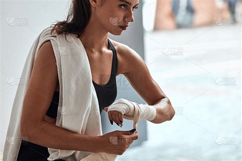 强壮的运动女孩在手上裹着绷带准备训练