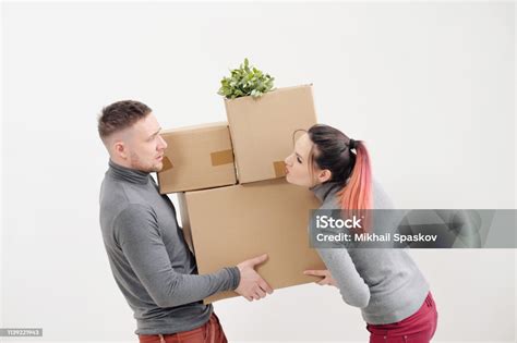 한 청 녀와 남자가 무거운 골 판지 상자를 들고 다니는 것입니다 화이트 라이트 아파트입니다 그들은 웃음과 키스 2명에 대한 스톡 사진 및 기타 이미지 Istock