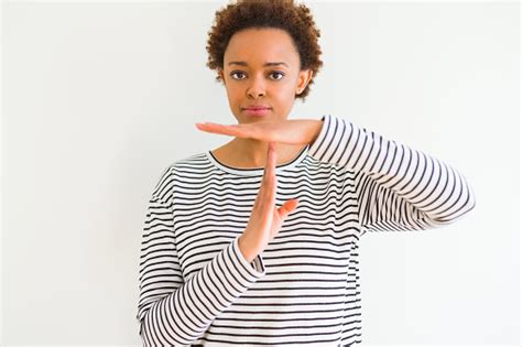 젊은 아름 다운 아프리카 계 미국인 여자 를 입고 줄무늬 스웨터 위에 흰색 배경 수행 시간 아웃 제스처 와 손 좌절과 심각한 얼굴 곱슬 머리에 대한 스톡 사진 및 기타