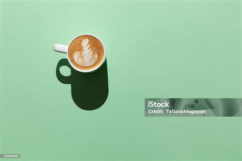 카푸치노가 있는 빈 흰색 머그잔 파스텔 그린 배경에 하드 라이트의 라떼 디자인 상단 보기 플랫 레이 디자인모형 최소한의 스타일