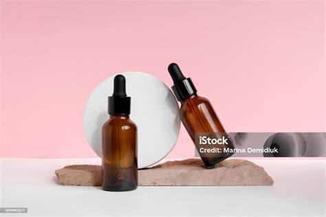 호박색 유리 점적기 화장품 병 흰색 연단 자연 스킨 케어 Spa 뷰티 제품 디자인 분홍색 배경에 미네랄 유기농 오일 모형 기름진 피펫 얼굴과 몸 치료 정면보기 0명에 대한