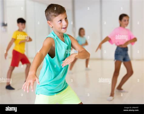 Cheerful Preteen Boy Learning Energetic Dance Moves In Choreography
