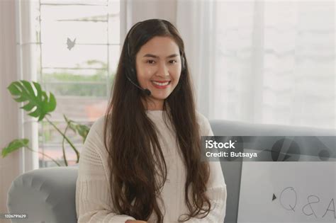 거실에서 화상 채팅을하는 헤드셋을 착용한 젊은 매력적인 스마일 아시아 여성 집에서 온라인 수업을 준비하는 헤드폰을 착용한 아시아 강사 30 34세에 대한 스톡 사진 및 기타
