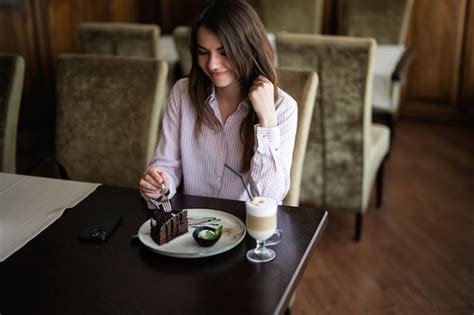 A Jovem E Bela Mulher Morena Senta Se No Café Restaurante Dentro De