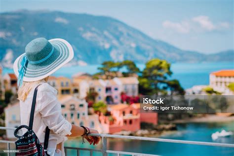 블루 Sunhat과 흰색을 입고 관광 여자 화창한 날에 즐기는 보기 다채로운 조용한 마 아소스의 옷 그리스 여행 휴가