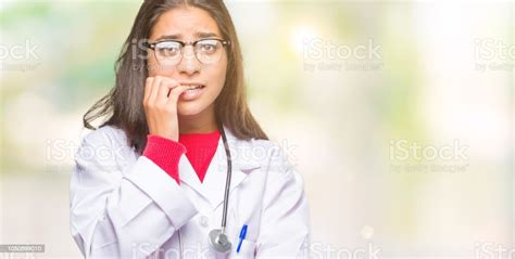 격리 된 배경에 강조 하 고 손톱을 물어 뜯고 입에 손을 긴장을 찾고 젊은 아랍 의사 여자 불안 문제입니다 감정에 대한 스톡 사진 및 기타 이미지 Istock