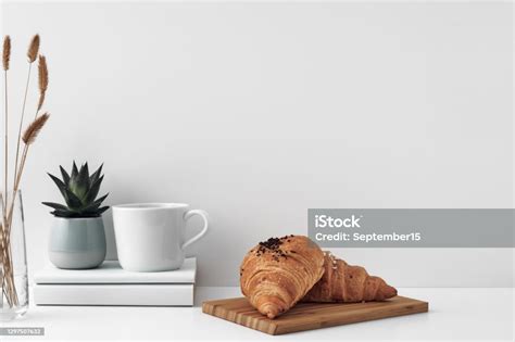 나무 스탠드에 크루아상과 머그잔 꽃병과 책 흰색 배경에 식물이있는 냄비 실내 장식 미니멀리즘의 친환경 소재 공간을 복사하고 모의합니다 0명에 대한 스톡 사진 및 기타 이미지