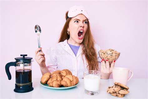 Joven Y Hermosa Pelirroja Sentada En La Mesa Desayunando Enfadada Y Furiosa Gritando Frustrada Y