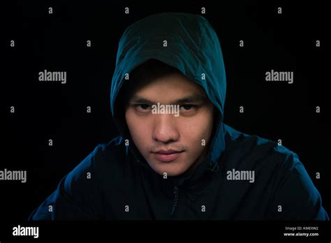 Asian Hacker Hacking Computer Network With Laptop In Dark Cyber