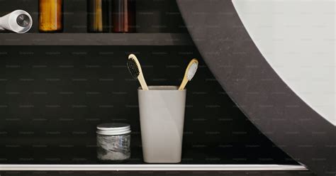 폐기물 제로 개념 플라스틱 무료 대나무 칫솔 유리에 숯 치약 피부를위한 Ubtan 컨디셔너 탈취제 검은 선반에 현대적인 욕실의 강장제 천연 필수품 사진