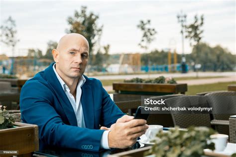 잘생긴 대머리 사업가 입고 재킷과 셔츠 거리에서 세련 된 현대적인 카페 테라스에서 전화를 들고 거리에 대한 스톡 사진 및 기타 이미지 Istock