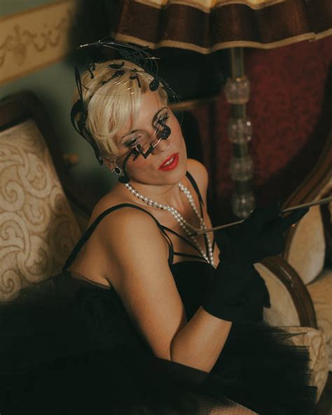 무료 사진 우아한 블랙 드레스와 머리에는 화려한 액세서리를 착용하고 화려한 포멀 코디를 입고 소파에 앉아 있는 여성의 초상화