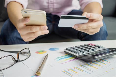 객실 내 소파에서 온라인 쇼핑을 위해 스마트폰과 신용카드를 들고 있는 손 Brand Name Mobile Payment에 대한 스톡 사진 및 기타 이미지 Brand