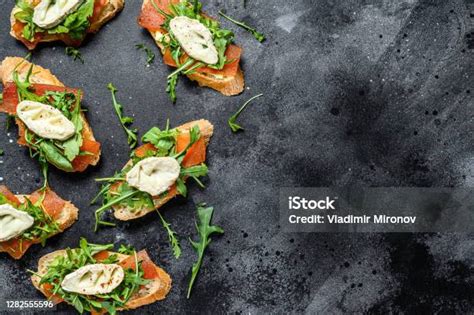 염소 치즈 아루굴라 배 마멀레이드를 곁들인 바게트 에 카나페 검은 색 배경 맨 위 보기입니다 공간을 복사합니다 건강한 식생활에