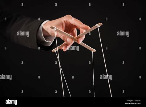 Woman Pulling Strings Of Puppet On Black Background Closeup Stock Photo Alamy