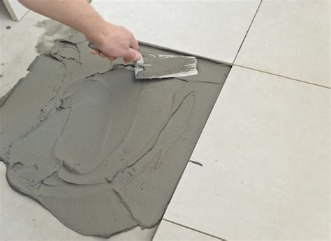 Premium Photo Laying Ceramic Tiles Troweling Mortar Onto A Concrete