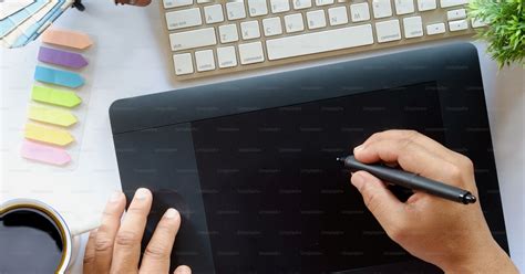 그래픽 태블릿을 사용하여 책상에서 작업을 수행하는 그래픽 디자이너 사진 Unsplash의 만화가 이미지