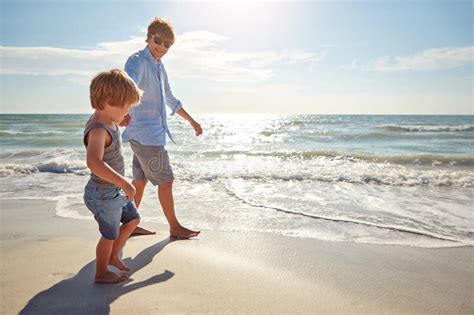 Walking In His Fathers Footsteps A Young Man And His Son Enjoying A Summer Day Out At The Beach
