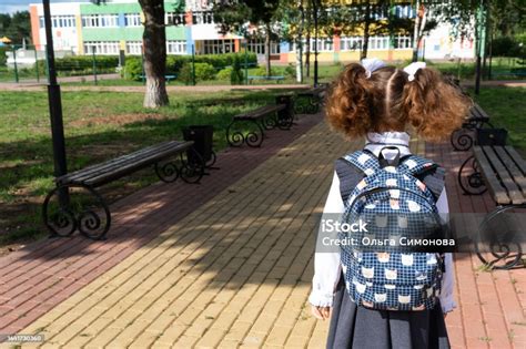 배낭을 메고 학교 운동장에서 교복을 입은 학생이 프레임으로 돌아갑니다 9월 1일 학교로 돌아갑니다 행복한 학생 초등 교육 초등 수업 삶으로 지식으로 가는 길 6 7 살에