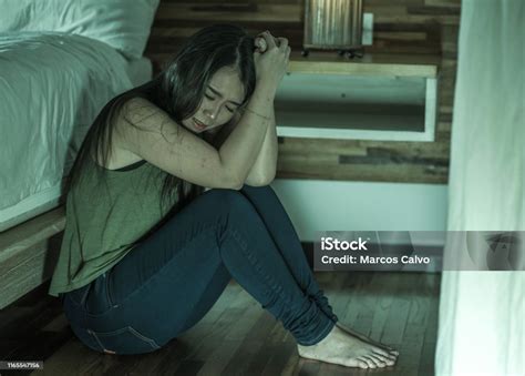 우울증 문제와 불안 위기를 겪고 있는 침대 옆 침실 바닥에 앉아 있는 젊은 우울하고 슬픈 아시아 여성의 극적인 라이프스타일 초상화 30 39세에 대한 스톡 사진 및 기타