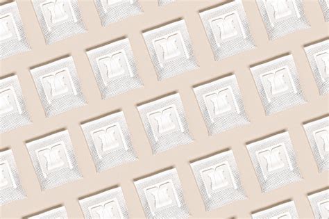 컵에서 양조를위한 분쇄 커피가있는 드립 커피 백 베이지 색 배경에 종이 봉지 드립 커피 필터가있는 패키지 상단보기 최소 플랫