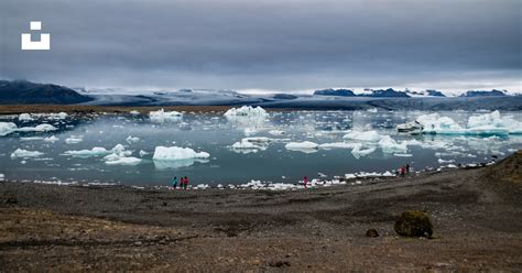 물에 빙산이 있는 바위 해변에 서 있는 한 무리의 사람들 사진 Unsplash의 무료 글레이셔 라군 이미지