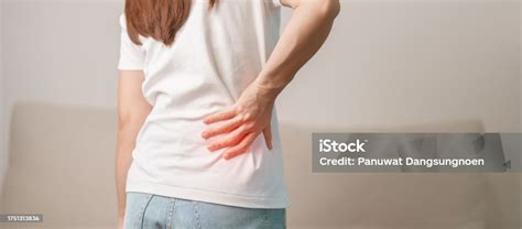 집에서 소파에 앉아 있는 동안 허리가 아픈 여자 이상근 증후군 요통 및 척추 압박으로 인한 근육통이 있는 성인 여성 사무실 증후군과 의료 개념 근육에 대한 스톡 사진 및