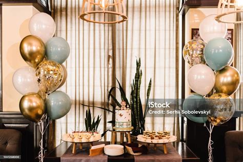 맛있는 리셉션 축제 어린이 침례 케이크 배경 풍선 파티 장식에 생일 케이크 공간을 복사합니다 축하 개념입니다 트렌디 한 케이크 캔디 바 과자 사탕 디저트가있는 테이블 풍선에