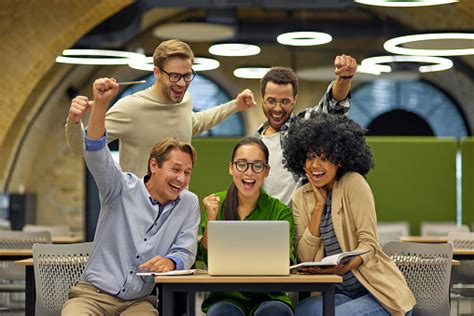 현대 사무실이나 코워킹 공간의 책상에 앉아 노트북 화면을 보고 성공을 축하하는 젊은 행복한 다인종 비즈니스 사람들의 그룹 다민족 그룹에 대한 스톡 사진 및 기타 이미지
