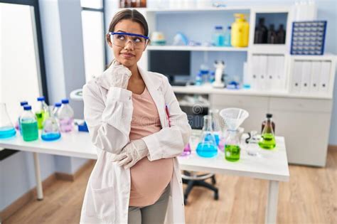 Young Pregnant Woman Working At Scientist Laboratory Serious Face