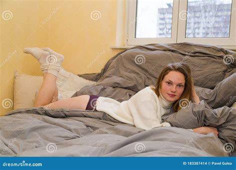 Девушка в теплых лжи свитер и трусов в кровать Стоковое Фото изображение насчитывающей