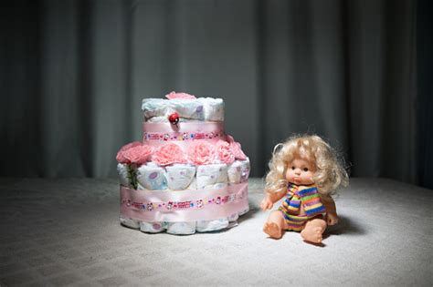 신생아 선물 개념입니다 기저귀 케이크입니다 꽃 케이크로 포장된 기저귀입니다 아기 인형 장식 테이블에 래핑된 깨끗 한 기저귀의
