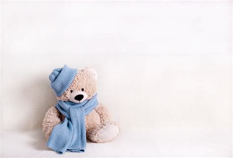 어린이 장난감 테디 베어는 파란색 니트 스카프와 모자에 흰색 소파에 앉아있다 가을에 대한 스톡 사진 및 기타 이미지 가을 개념 겨울 Istock