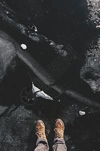 橡胶靴子下的危险薄薄冰的弧形裂缝高清图片下载 正版图片320815147 摄图网