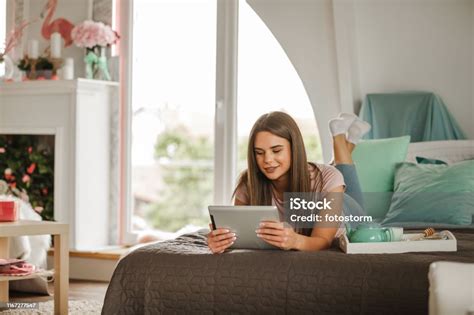 행복한 젊은 여자는 차와 디지털 태블릿 한 잔과 함께 침대에서 휴식 가정 생활에 대한 스톡 사진 및 기타 이미지 가정 생활 낮 누워있기 Istock