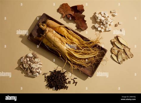 Image Of Fresh Ginseng Roots On Wooden Tray Decorated With Different Types Of Herbs On Beige