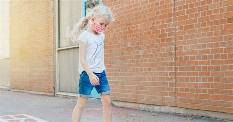 학교 운동장에서 점프 홉스카치를 하는 얼굴 마스크를 쓴 어린 소녀 야외 놀이터에서 아이들을위한 재미있는 활동 게임 어린이를위한 거리 스포츠 코로나바이러스 코로나19