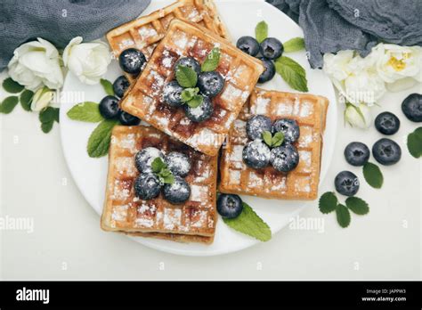 Belgian Waffles With Fresh Blueberries And Mint With White Flowers On